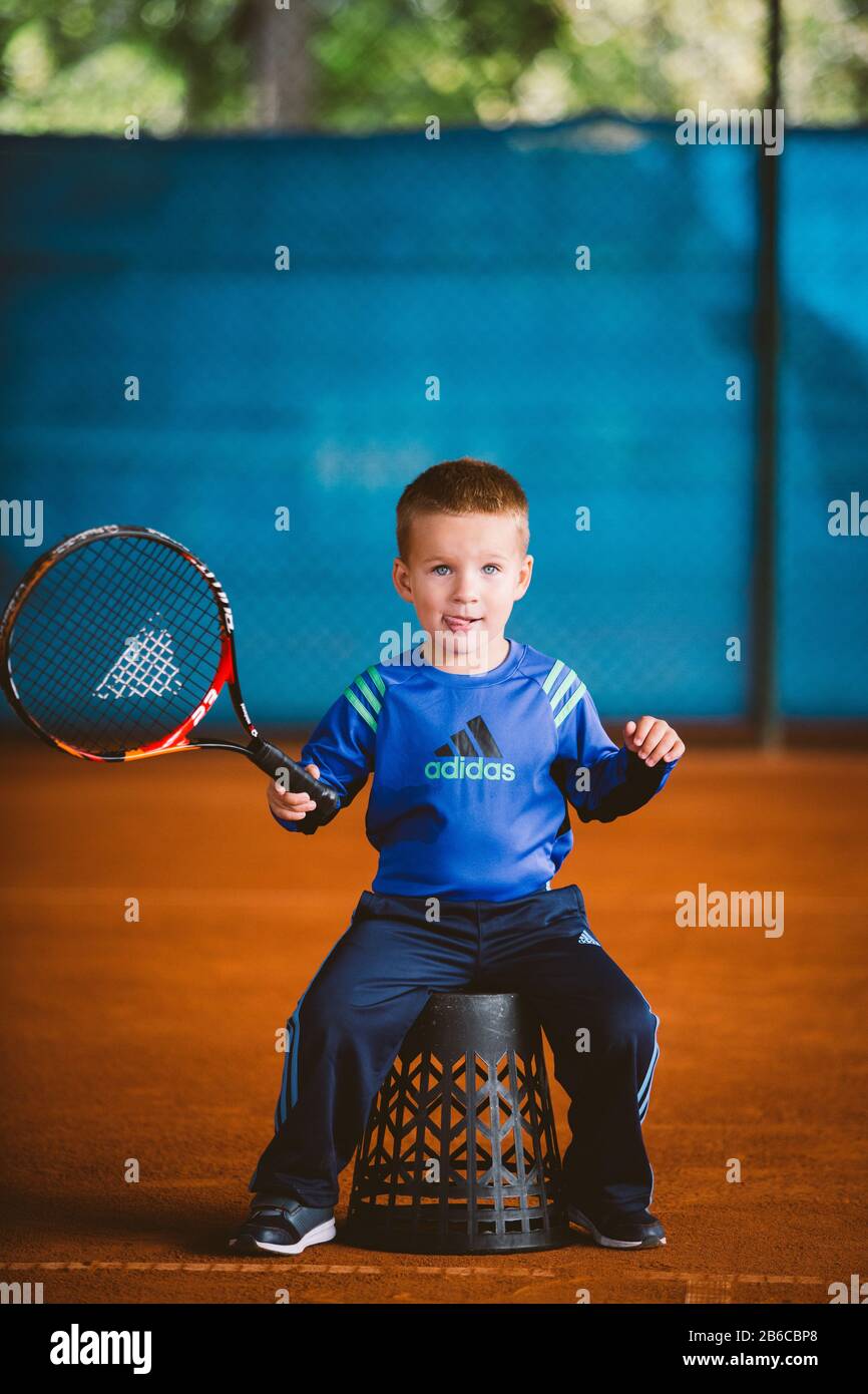 Child playing tennis on outdoor court. September 20, 2016. Ukraine ...