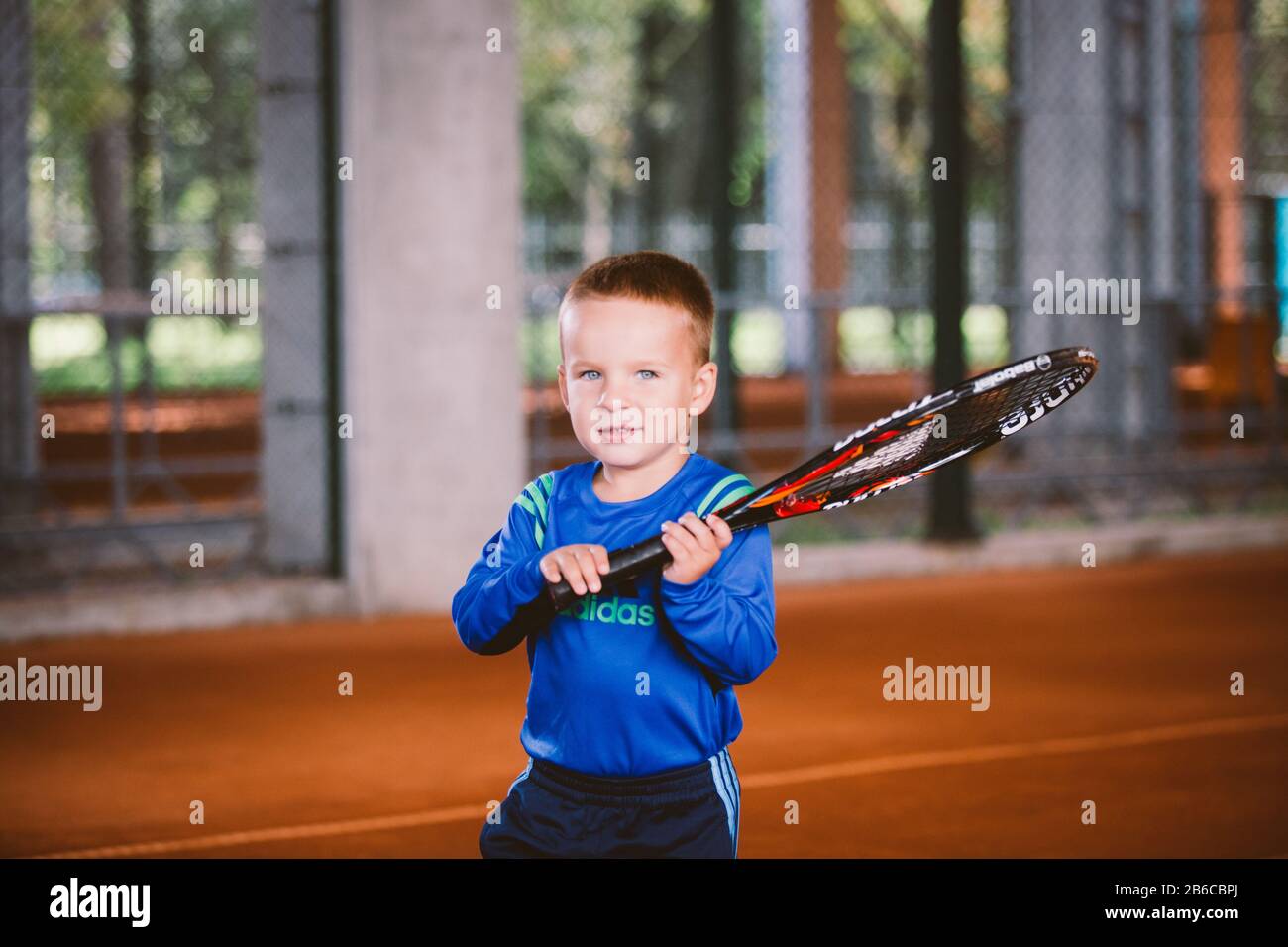 Child playing tennis on outdoor court. September 20, 2016. Ukraine ...