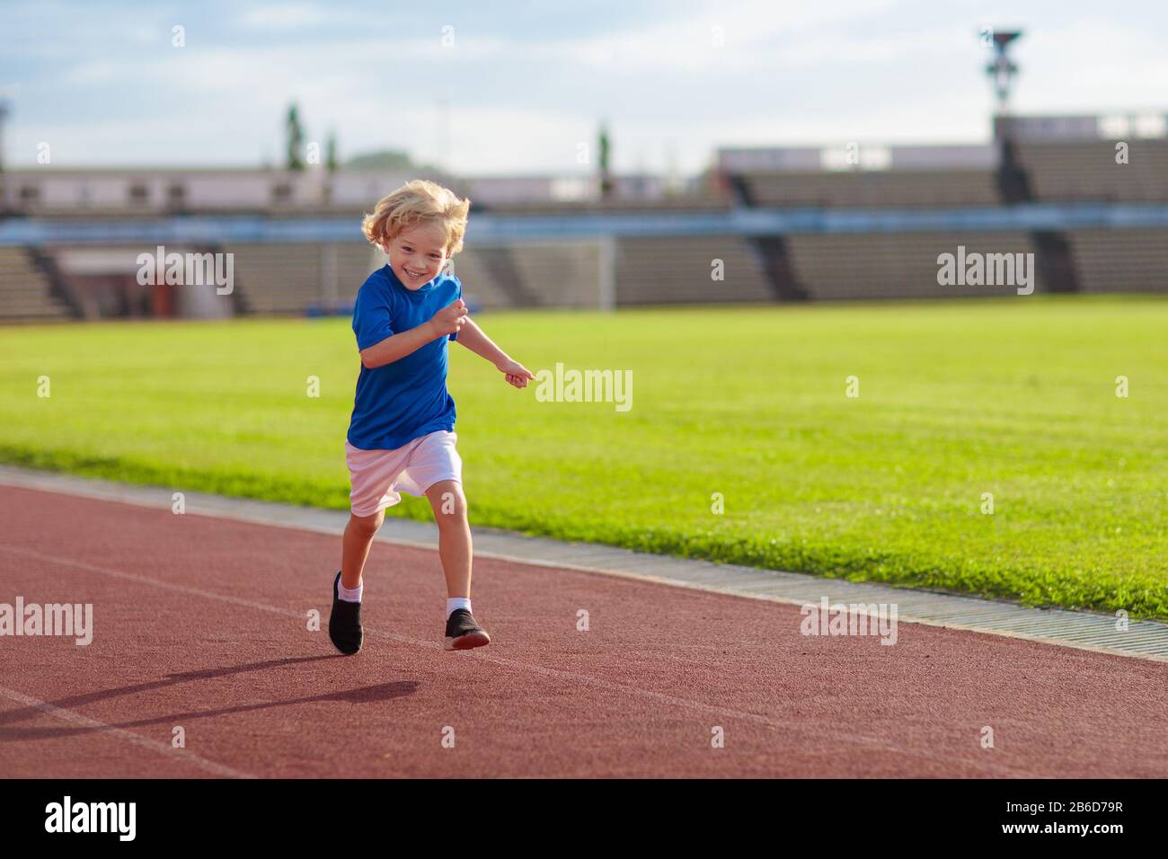 Child running in stadium. Kids run on outdoor track. Healthy sport ...