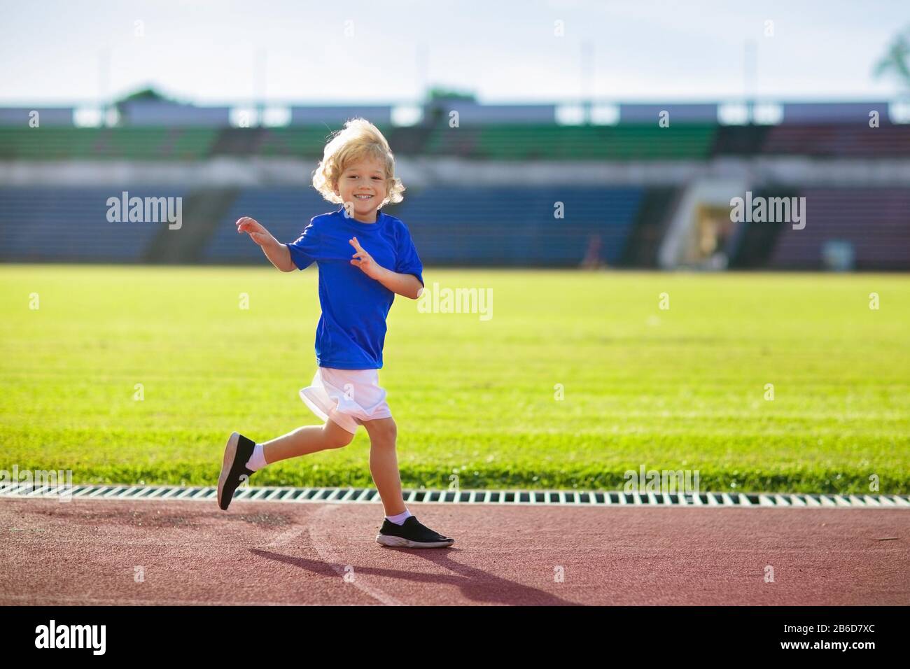 Child running in stadium. Kids run on outdoor track. Healthy sport ...