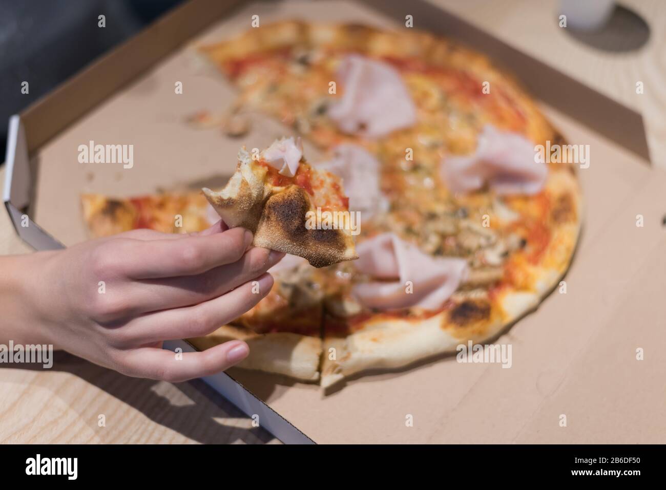 Beautiful woman eating pizza and drinking cola while sitting inside ...