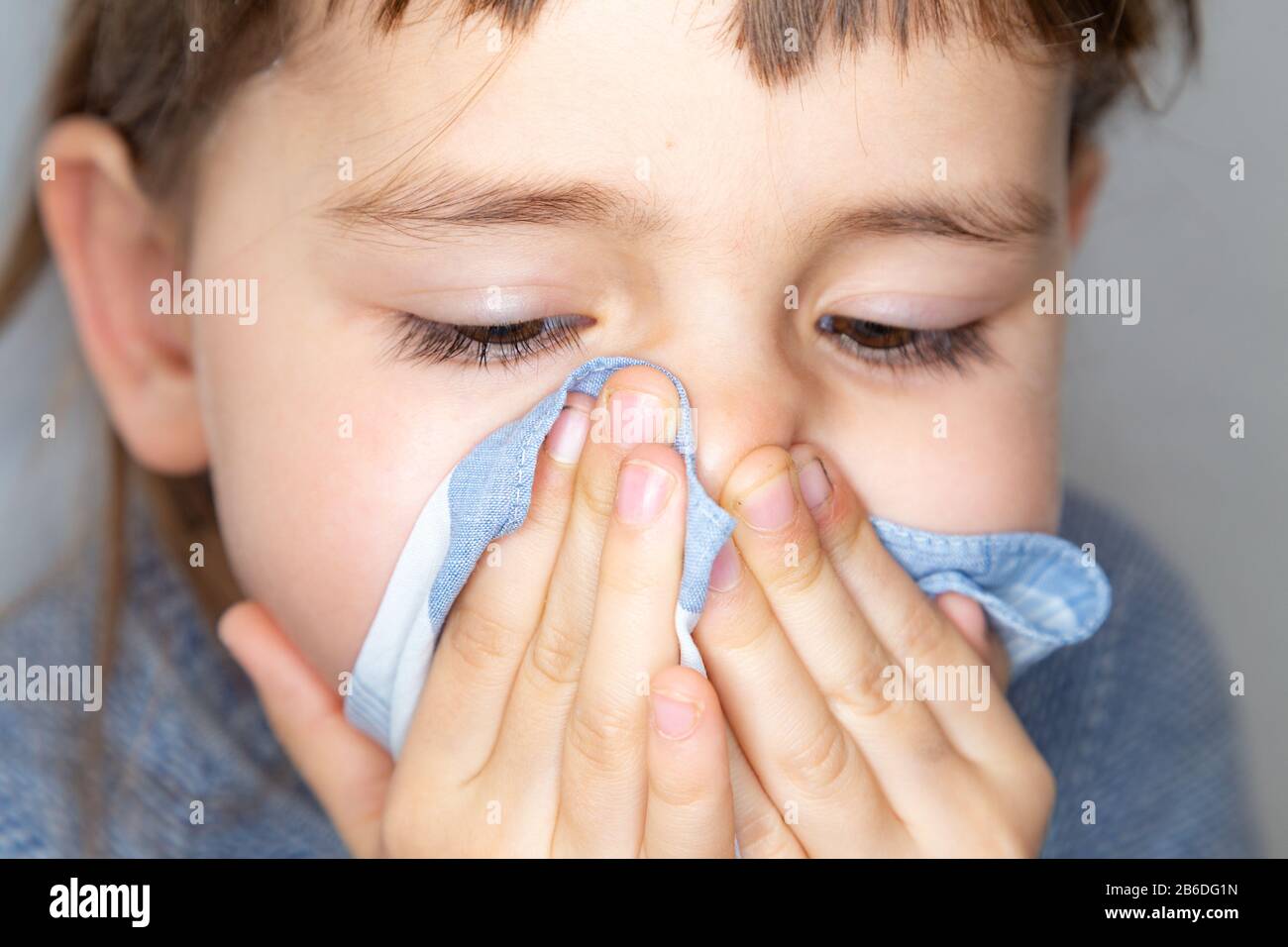 Close-up of young girl blowing her nose Stock Photo - Alamy