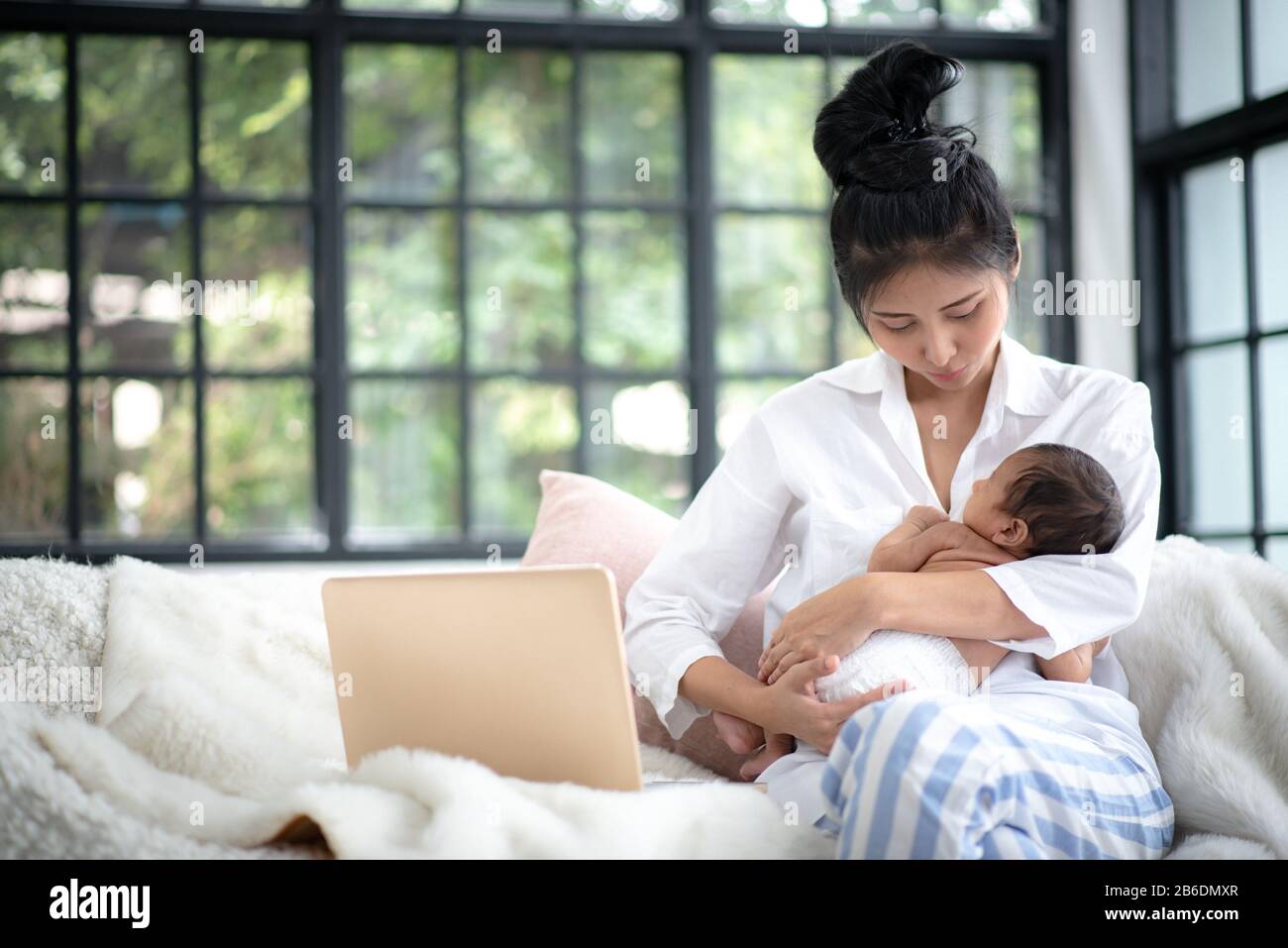 Adolescent mother is breastfeeding a baby Stock Photo - Alamy
