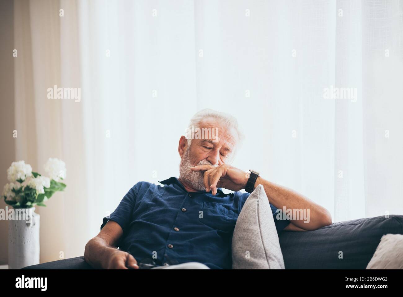 The old man is relaxing on the sofa Stock Photo - Alamy
