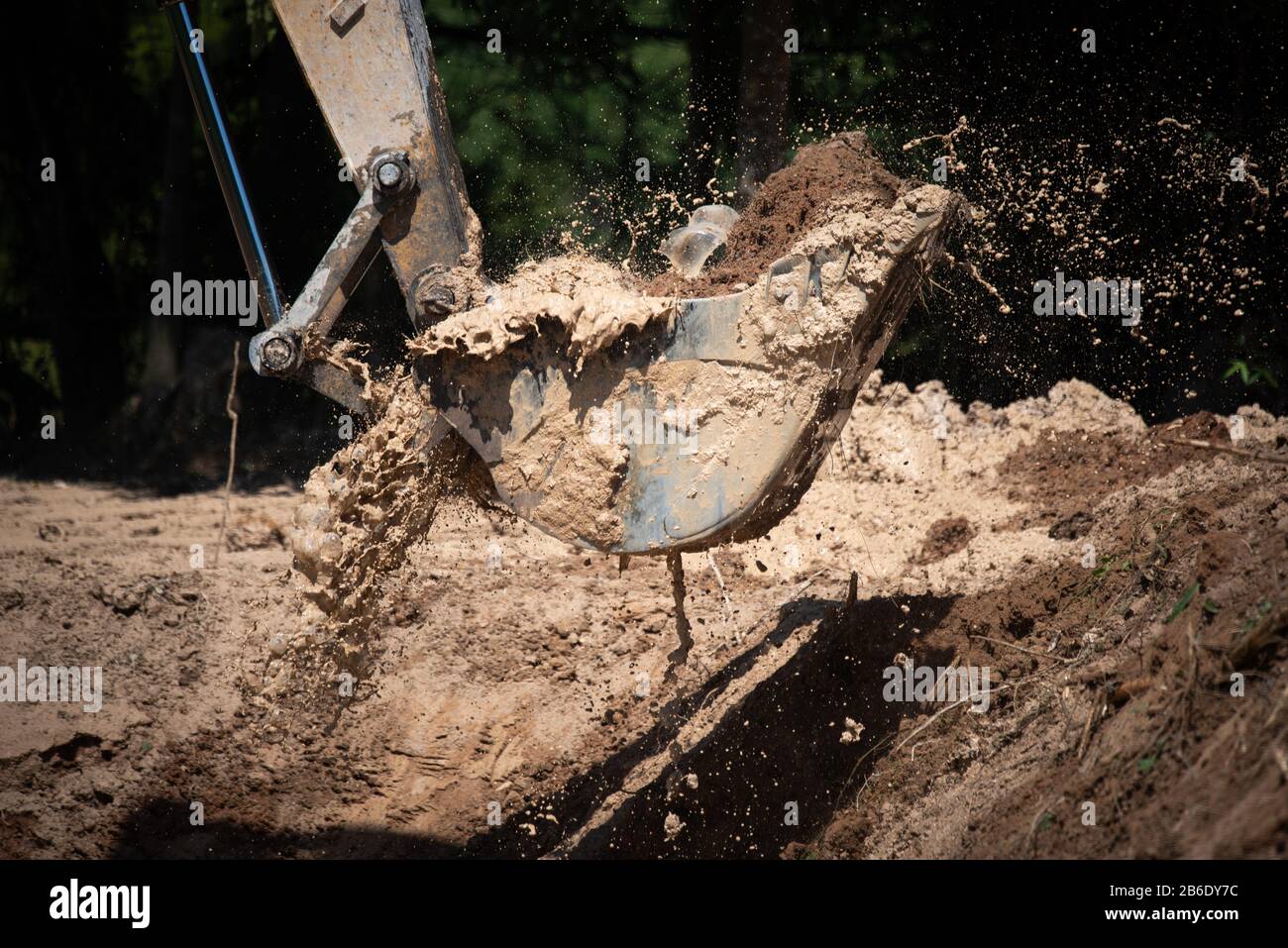 Excavator working with soil and water, during earthmoving works Stock ...