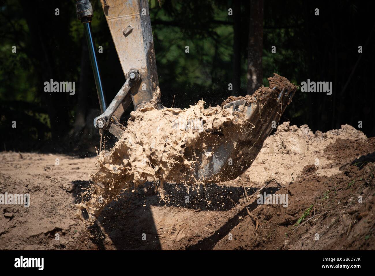 Excavator working with soil and water, during earthmoving works Stock ...