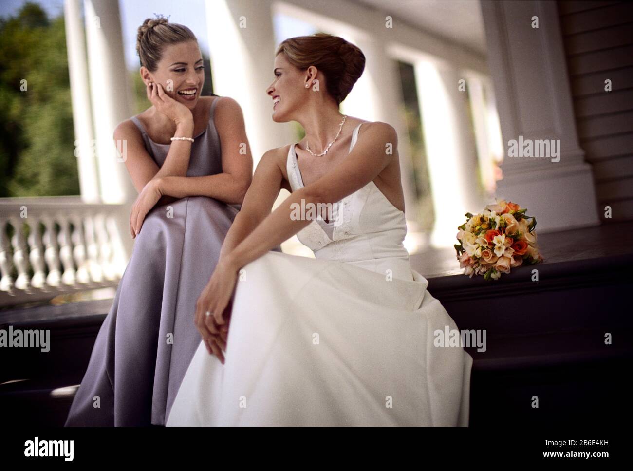 An attractive bride engaged in a pleasant conversation with her friend ...