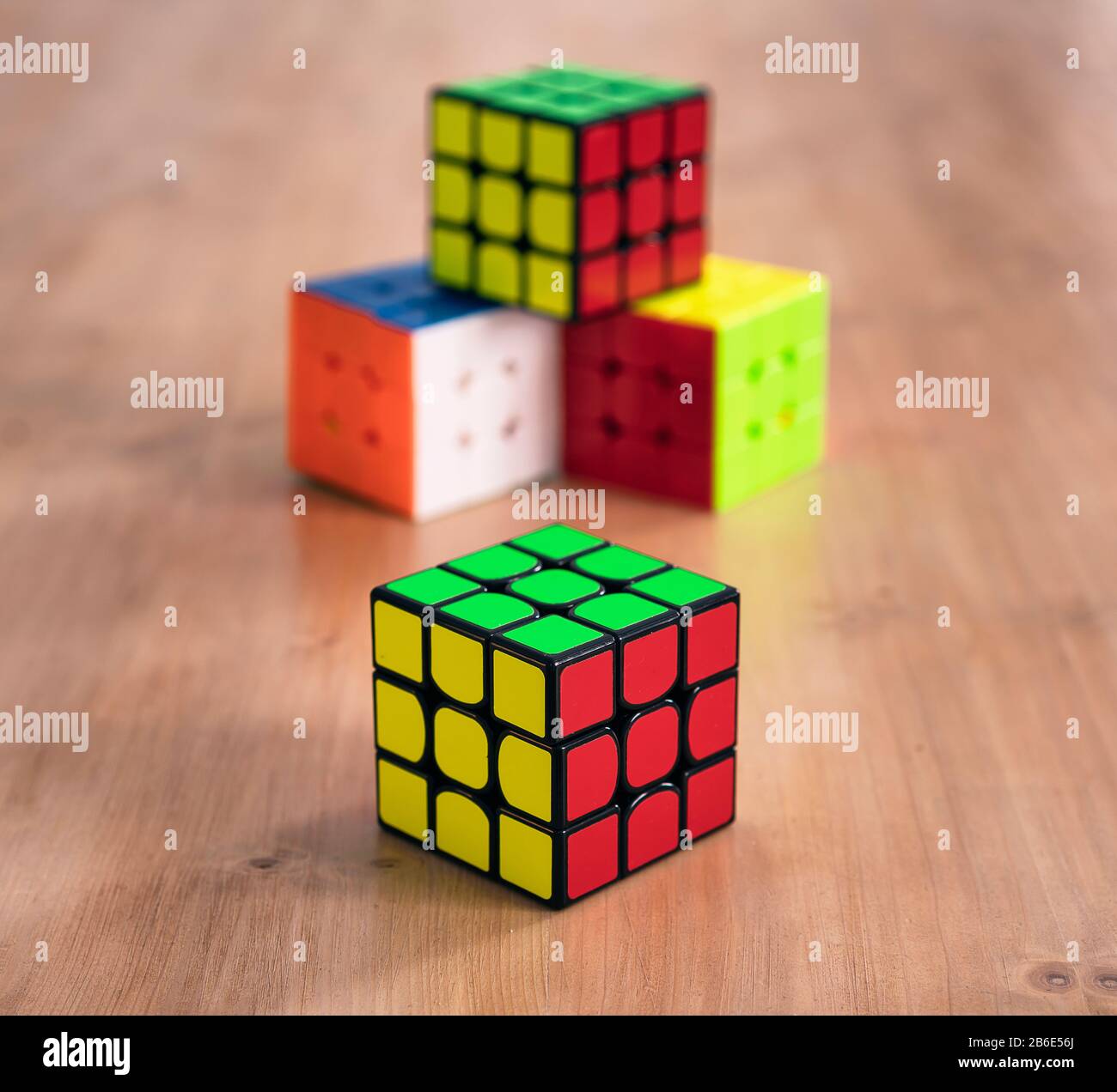 Several Rubik cubes intelligence toys solved, in a wood table Stock ...