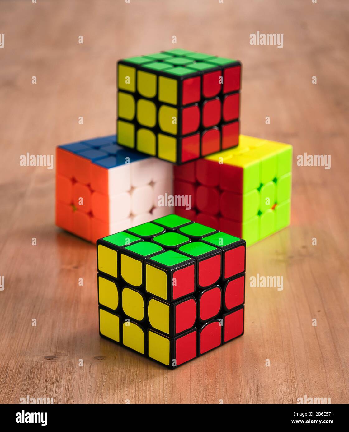Several Rubik cubes intelligence toys solved, in a wood table Stock ...