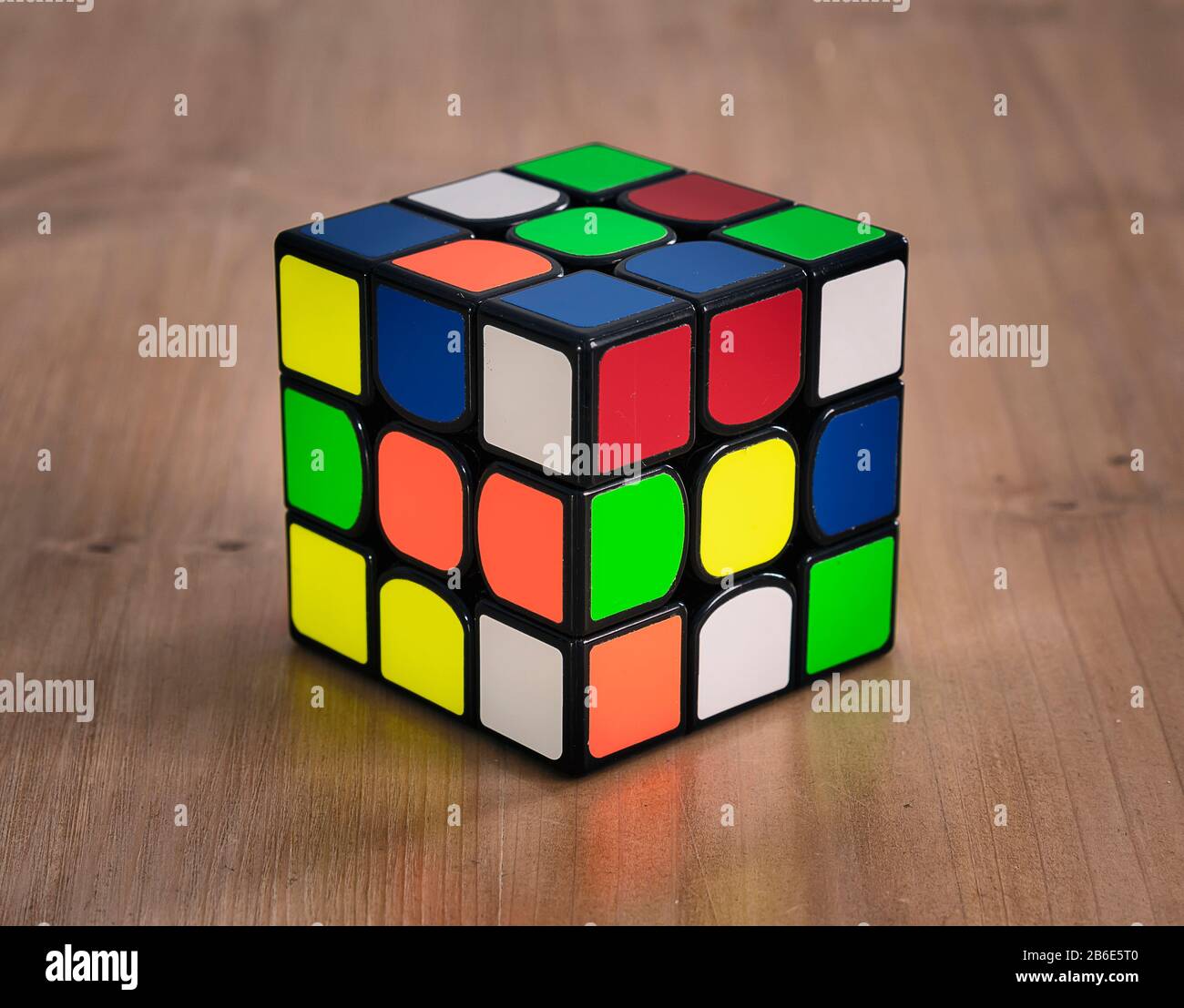 Several Rubik cubes intelligence toys unsolved, in a wood table Stock ...