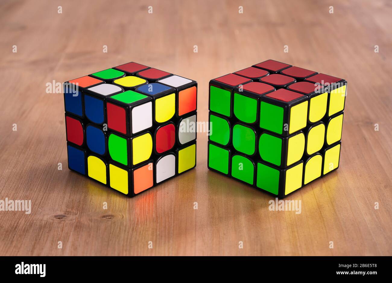 Several Rubik cubes intelligence toys unsolved, in a wood table Stock Photo - Alamy