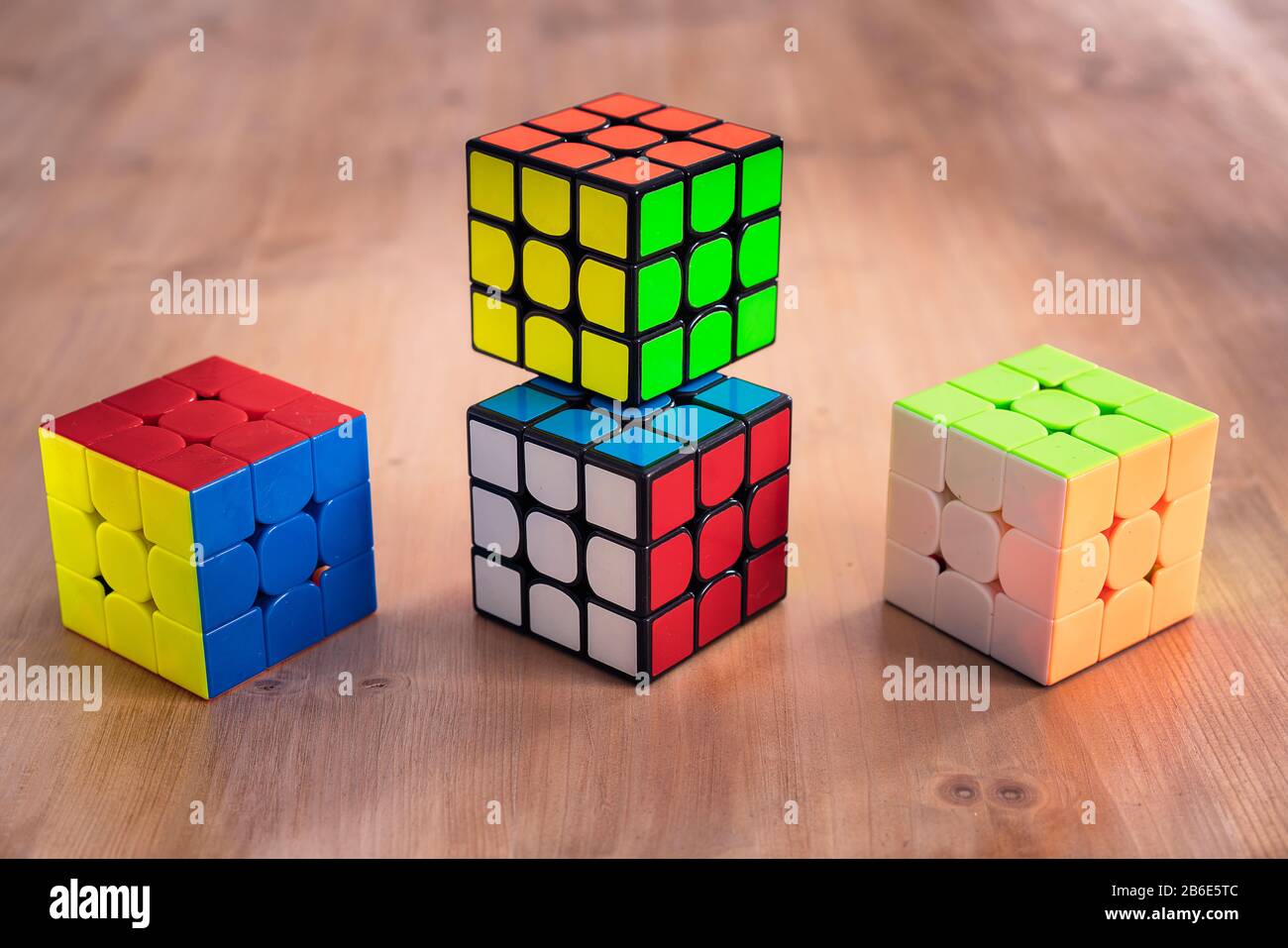 Several Rubik cubes intelligence toys solved, in a wood table Stock ...