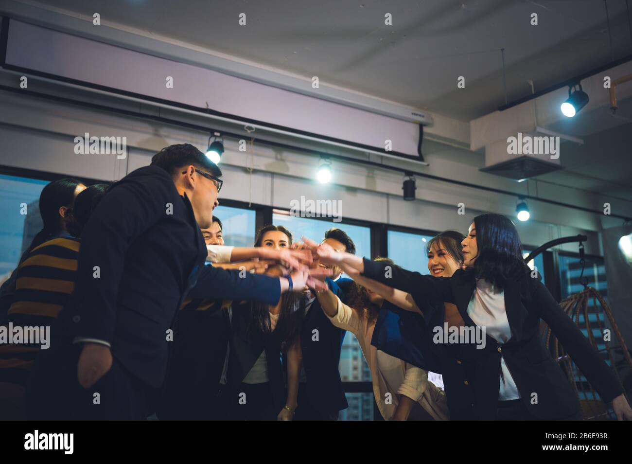 Large business team showing unity with their hands together Stock Photo - Alamy