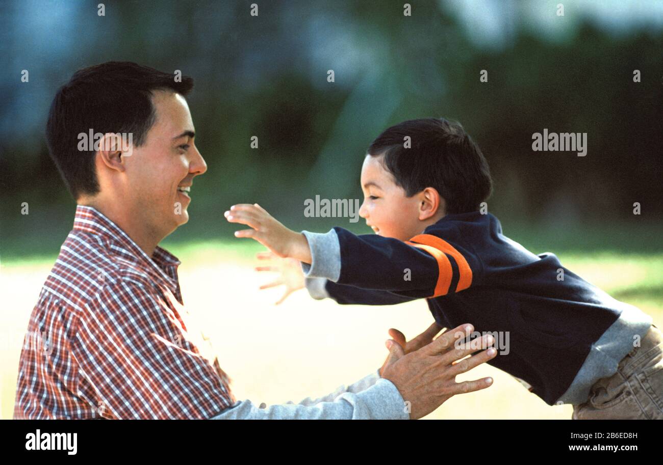 Mid adult man catching his son Stock Photo - Alamy