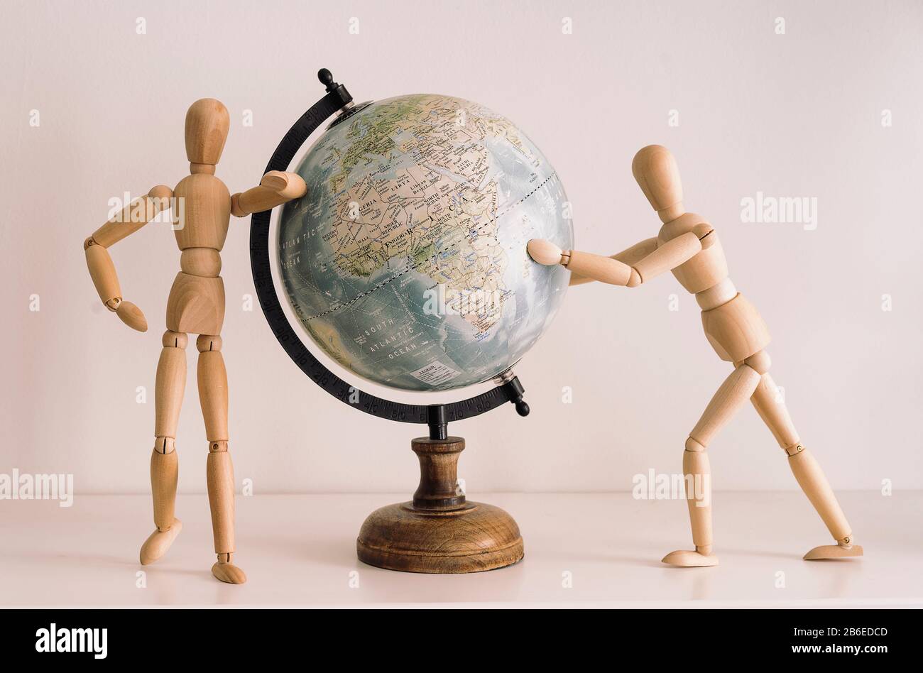 Wooden figures choosing travel destination on a world map. Travel ...