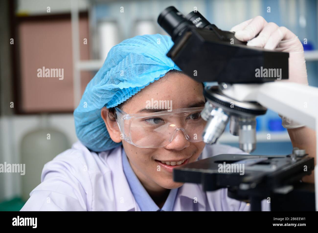 Young scientist looking through a microscope in a laboratory. Young ...