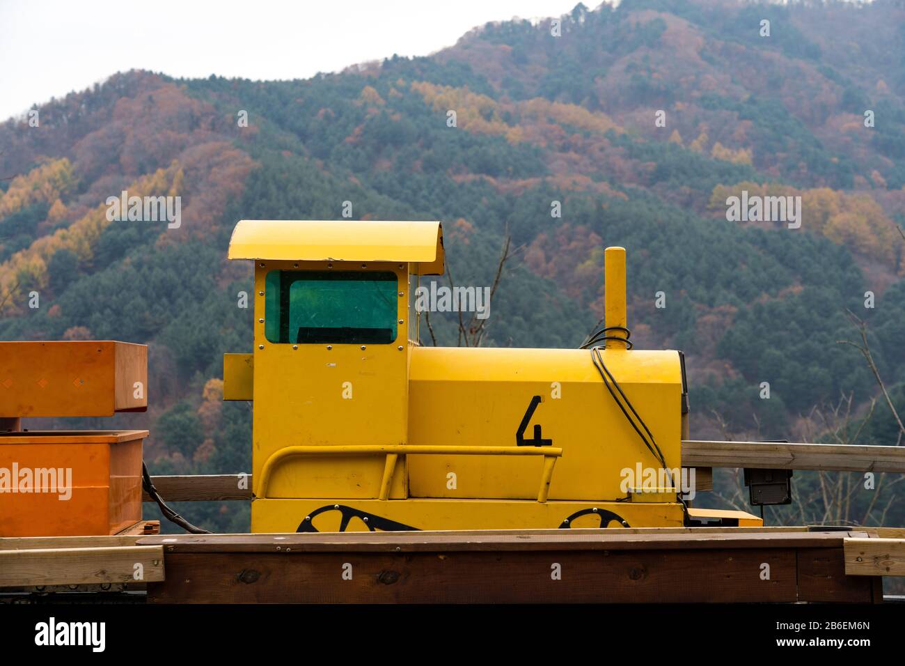 Yellow realistic miniature toy train in a railway Stock Photo - Alamy