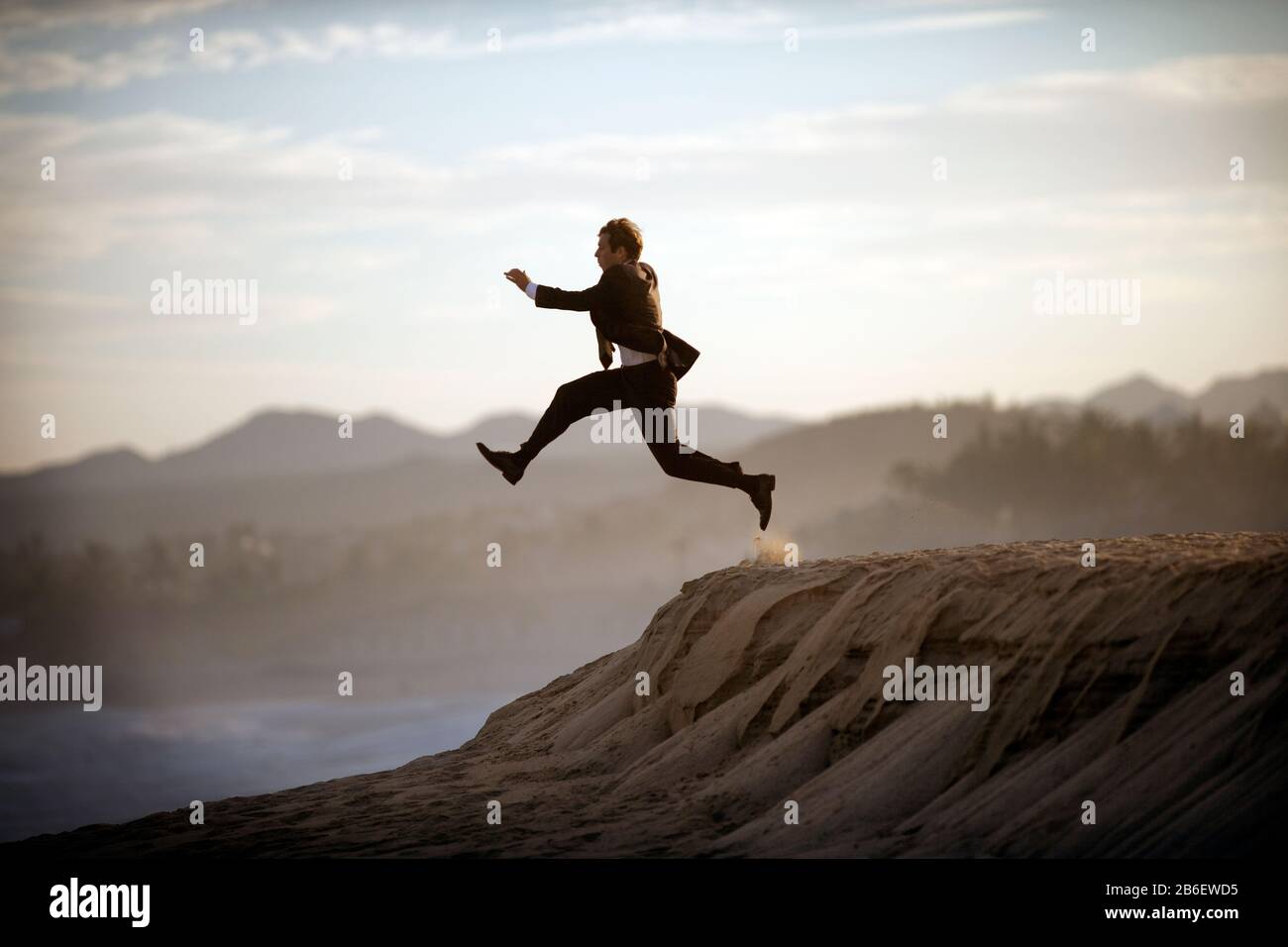 A man is seen in mid air as he jumps from the landform Stock Photo - Alamy
