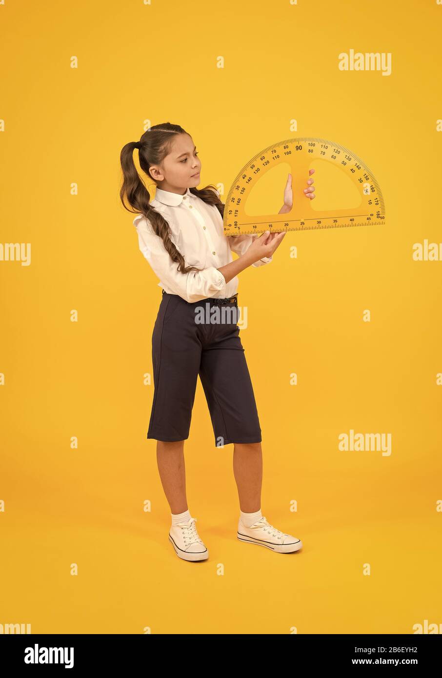 Setting square with protractor. Little girl using triangle to measure ...