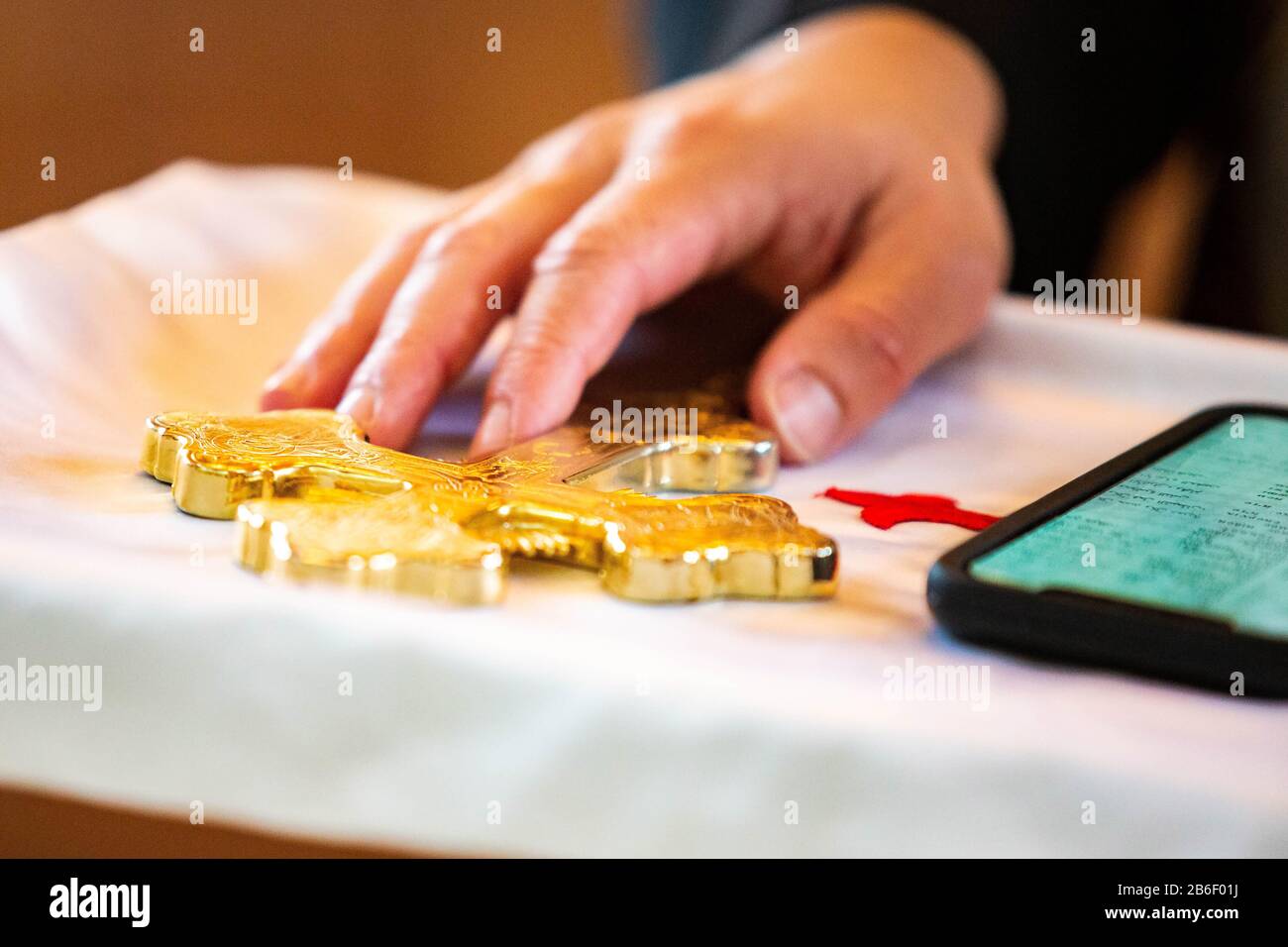 Holy father priest holding a golden cross symbol during sacred ceremony ...