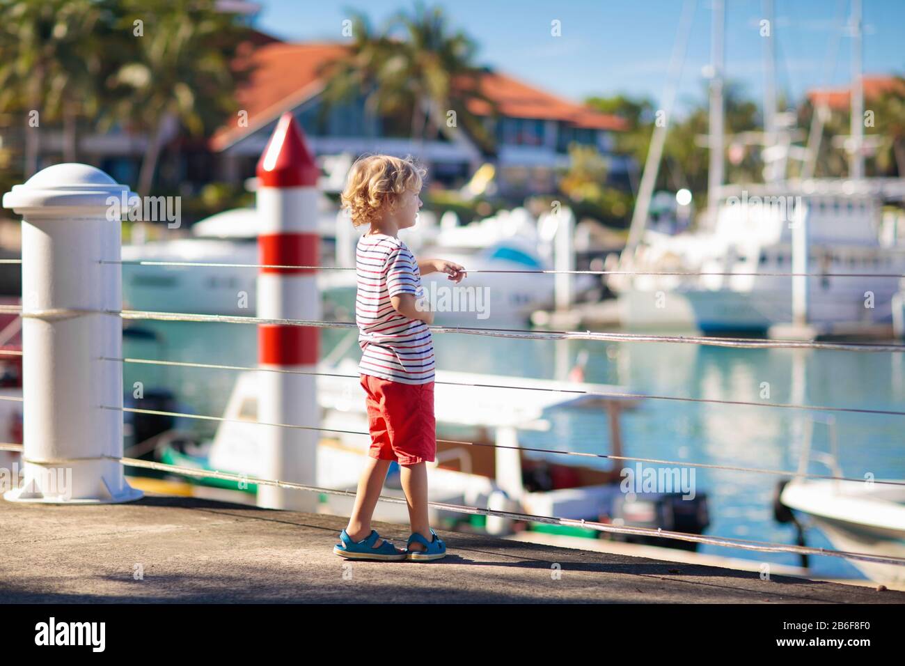 Child watching yacht and boat in harbor. Yachting sport for family with ...
