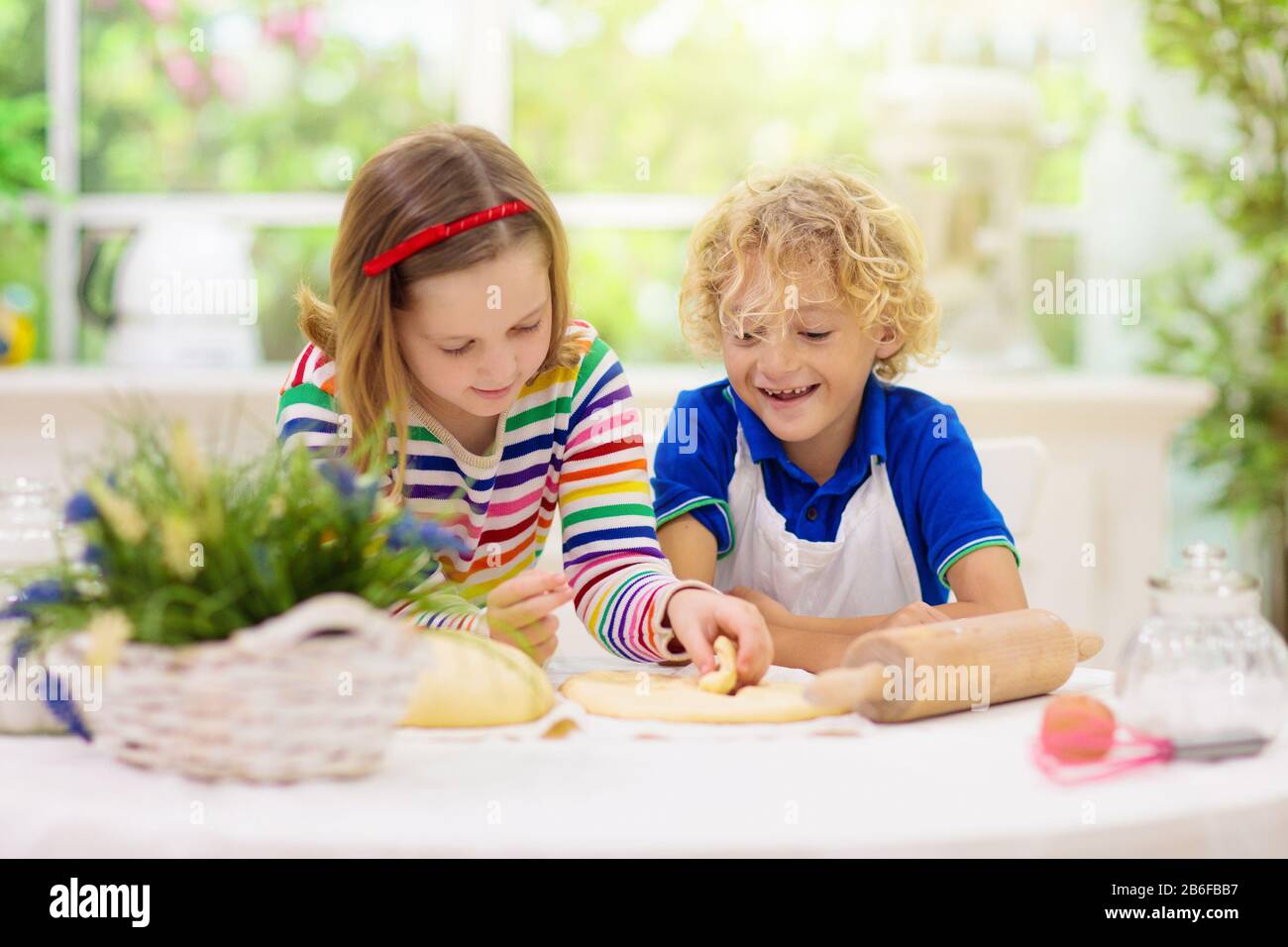 Kids baking pie in white sunny kitchen. Children cooking dinner. Boy ...