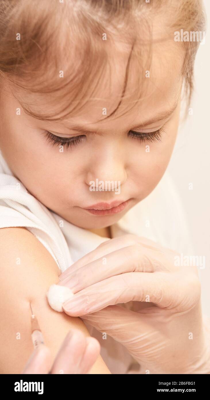 Doctor do injection to young girl. Kid immunization Stock Photo - Alamy