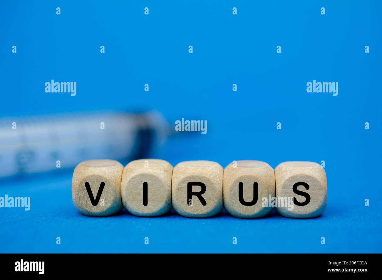 The word Virus on wooden cubes and syringe, blue background. Medical ...