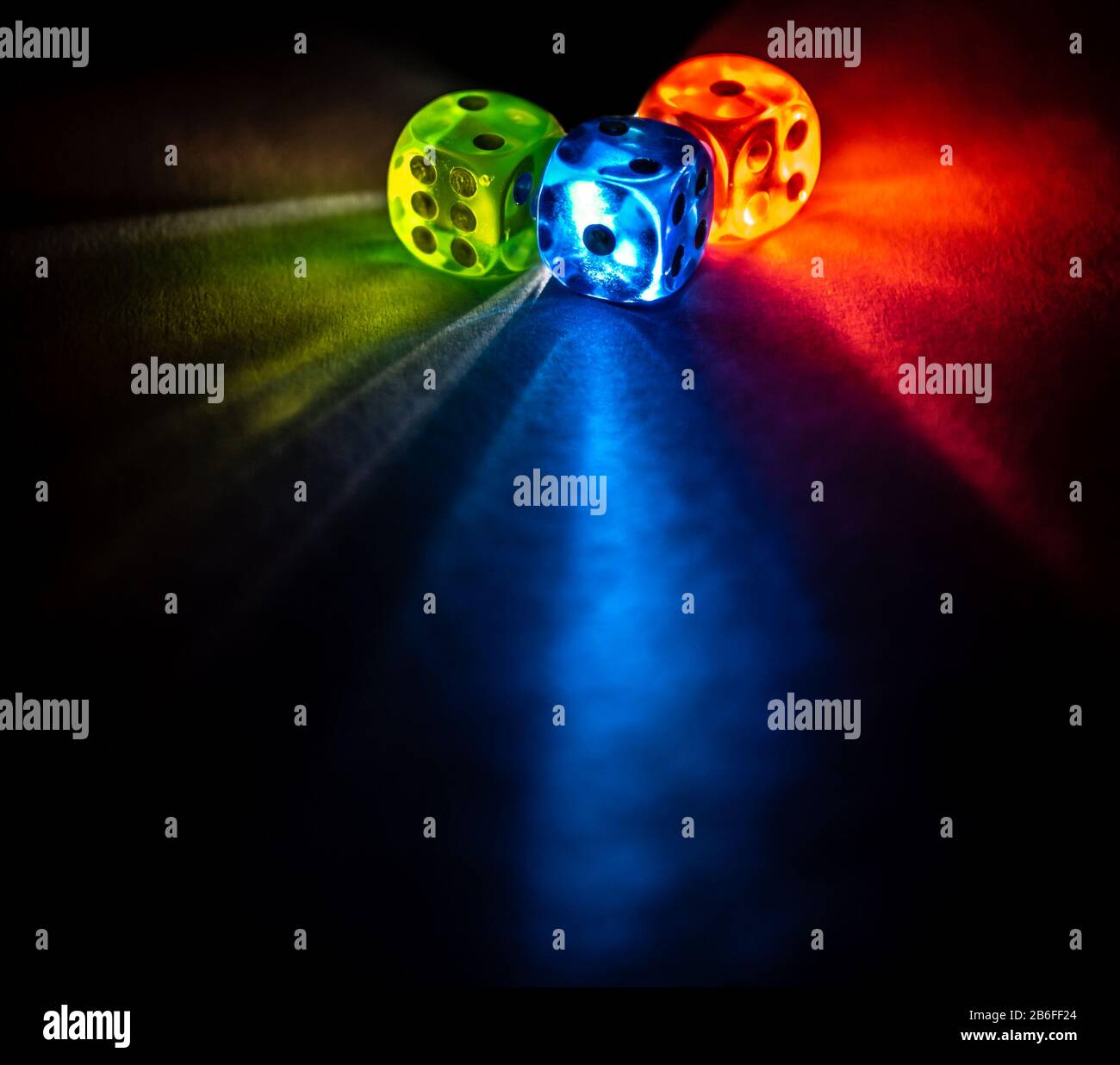 Dices of several colors, red, green, blue back illuminated with soft ...