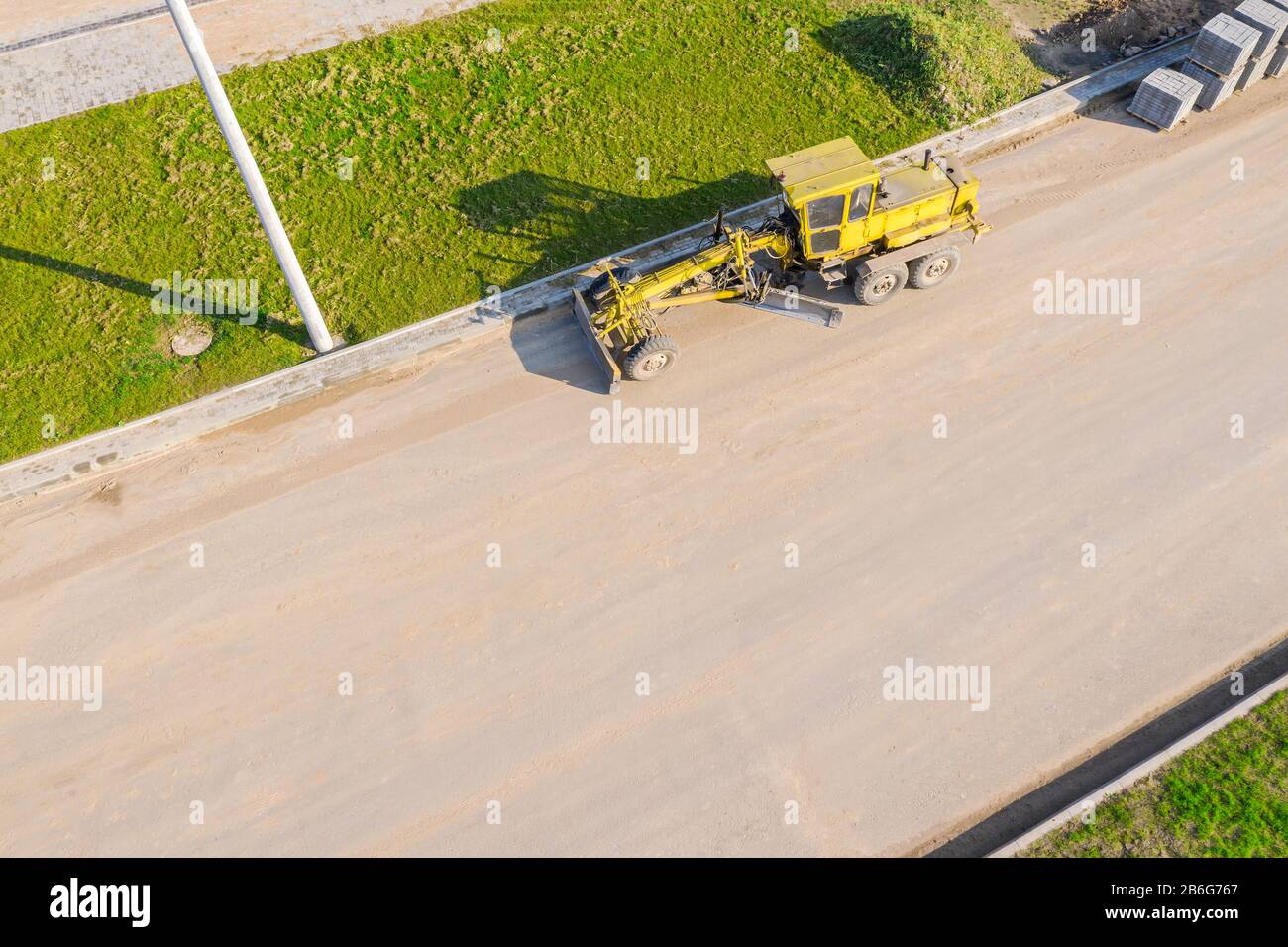 road grader standing at road construction site after use. aerial view ...