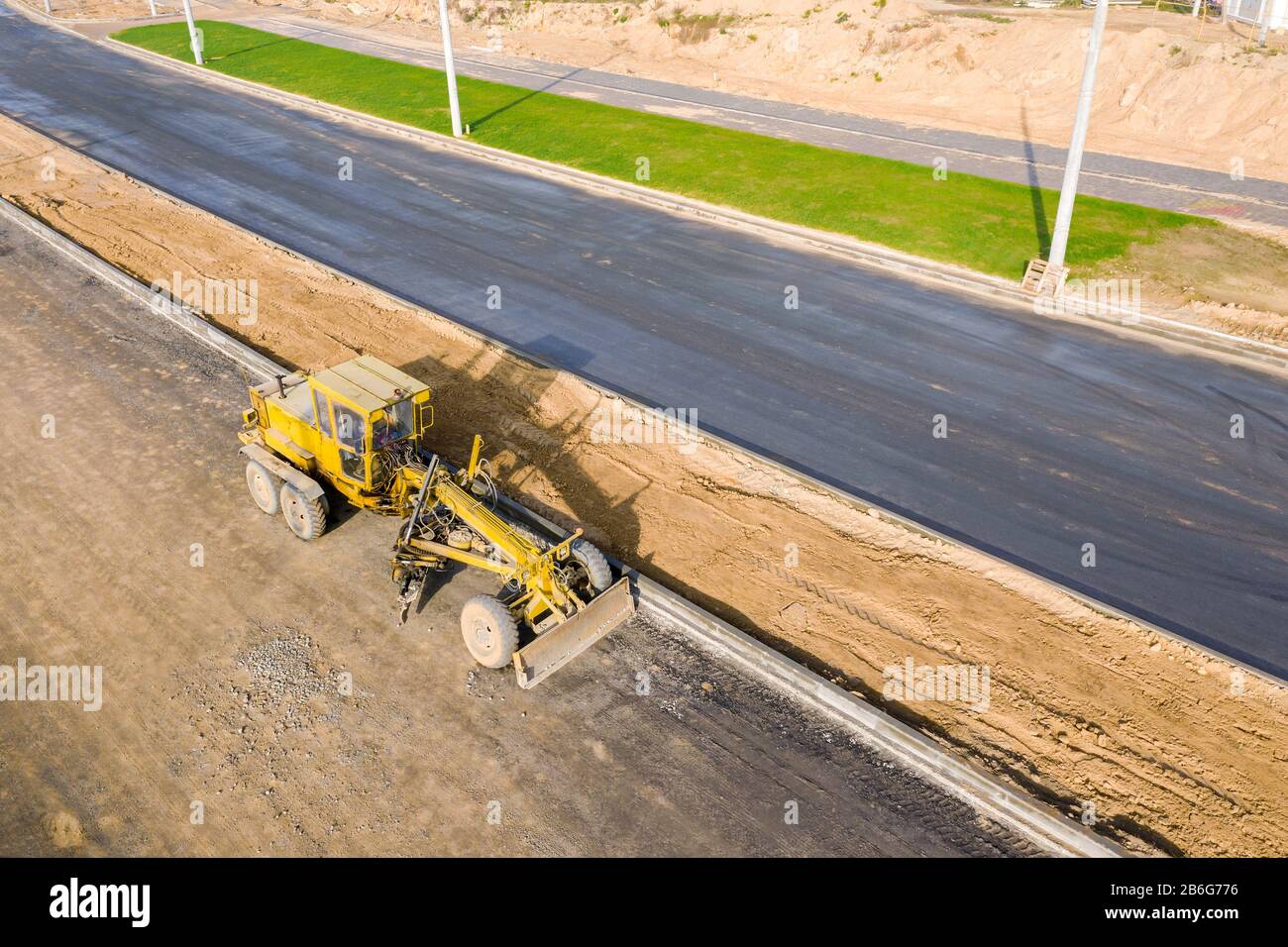 road grader on road construction site. machines work on the ...