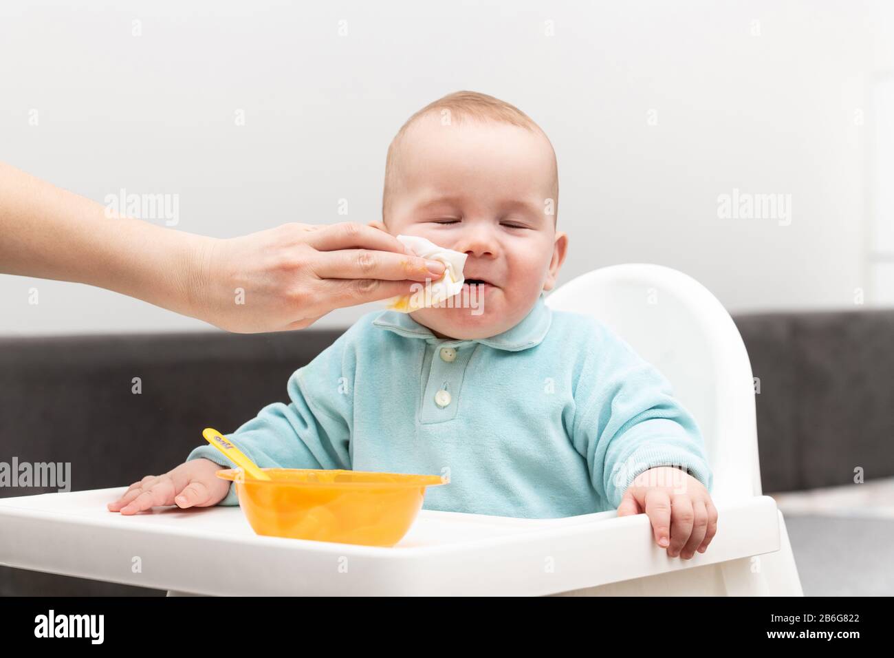 Mother Wipes Baby's Mouth With Napkin After Feeding Her Baby Son With ...