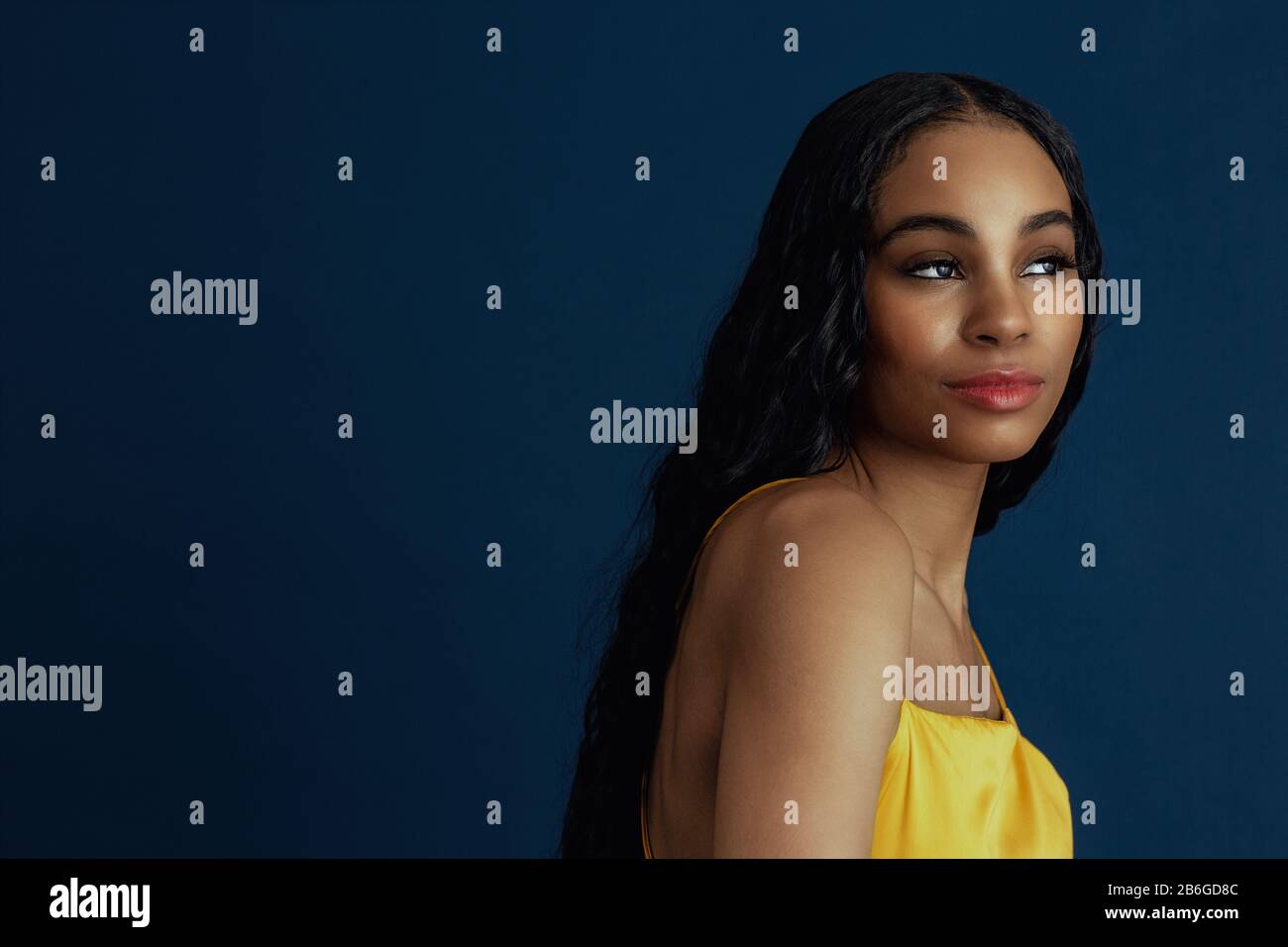 Portrait of a beautiful young woman with very long black curly hair ...