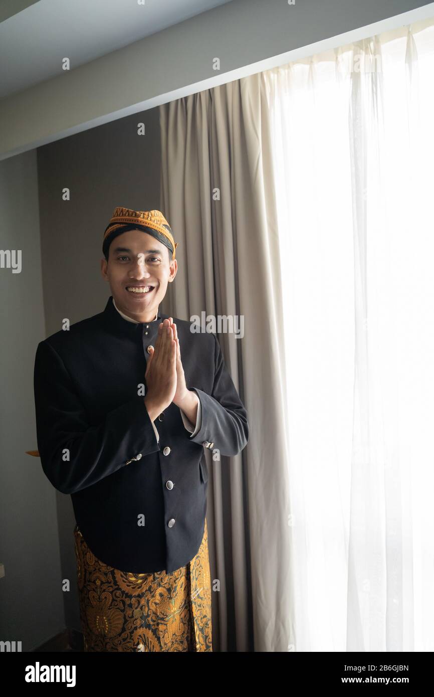 Asian man wearing traditional clothes with welcome gesture,beskap is ...