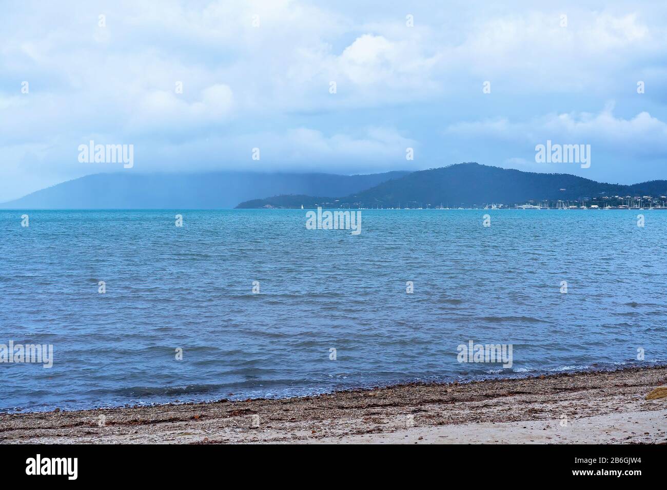 A light shower of rain coming across the ocean from a far shore in a ...