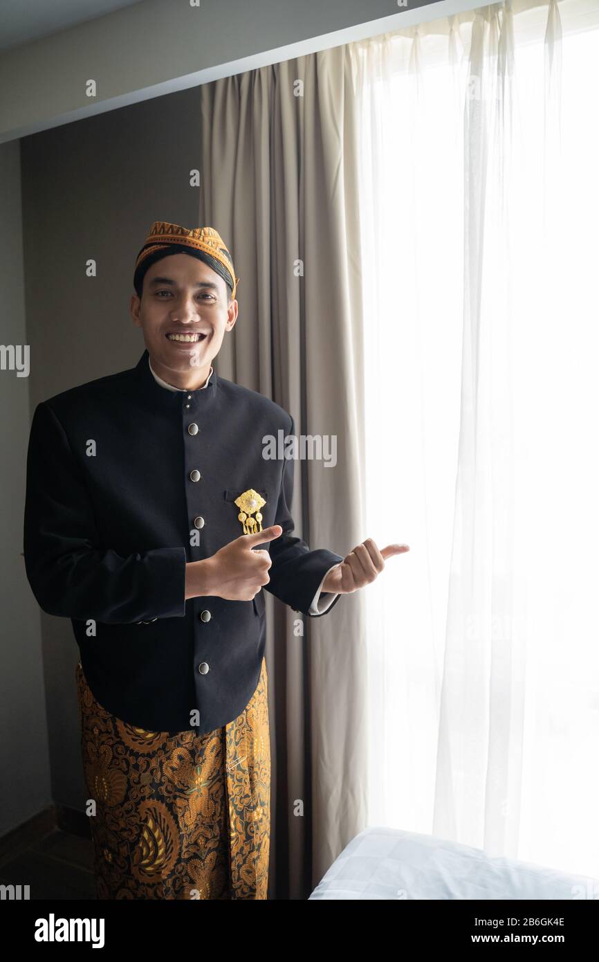 Young asian man wearing traditional clothes with gesture of thumb ...