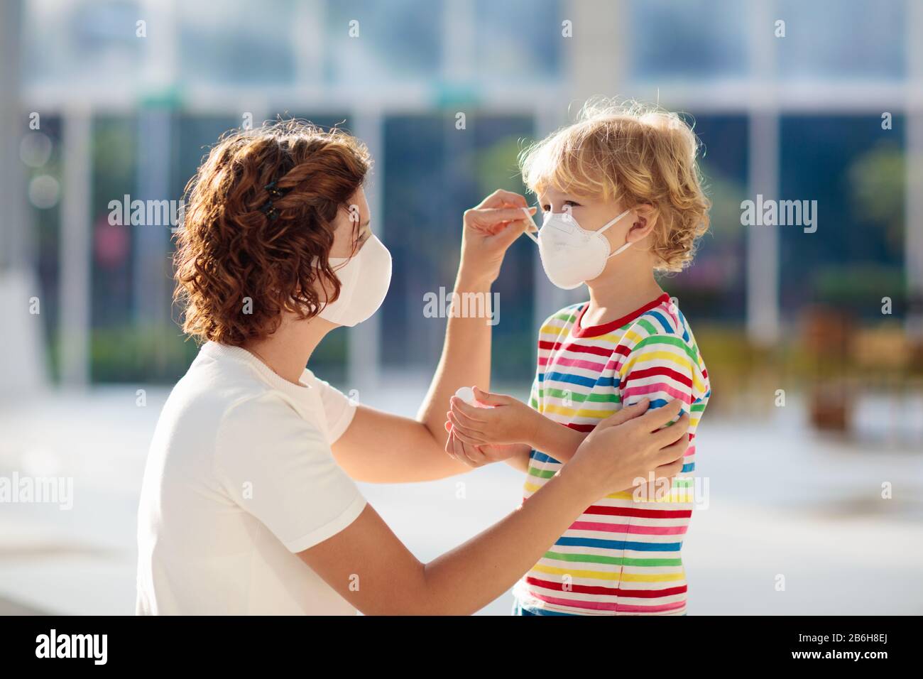 Family with kids in face mask in shopping mall or airport. Mother and ...