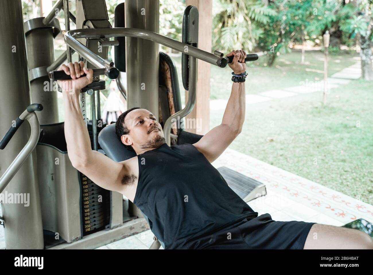 Asian young man doing chest press exercise at firness house Stock Photo ...
