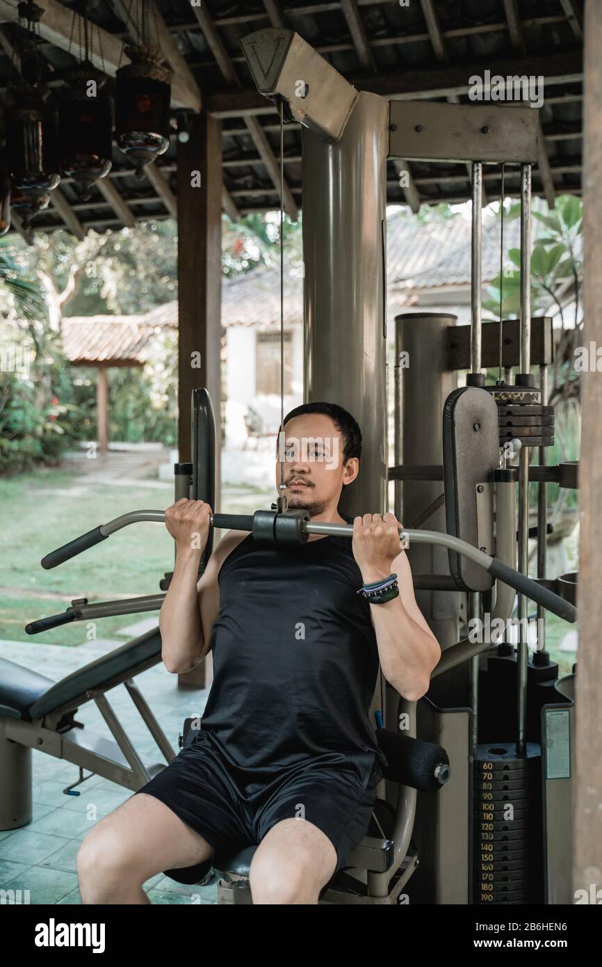 Asian man workout with lat pulldown machine in the gym house Stock ...
