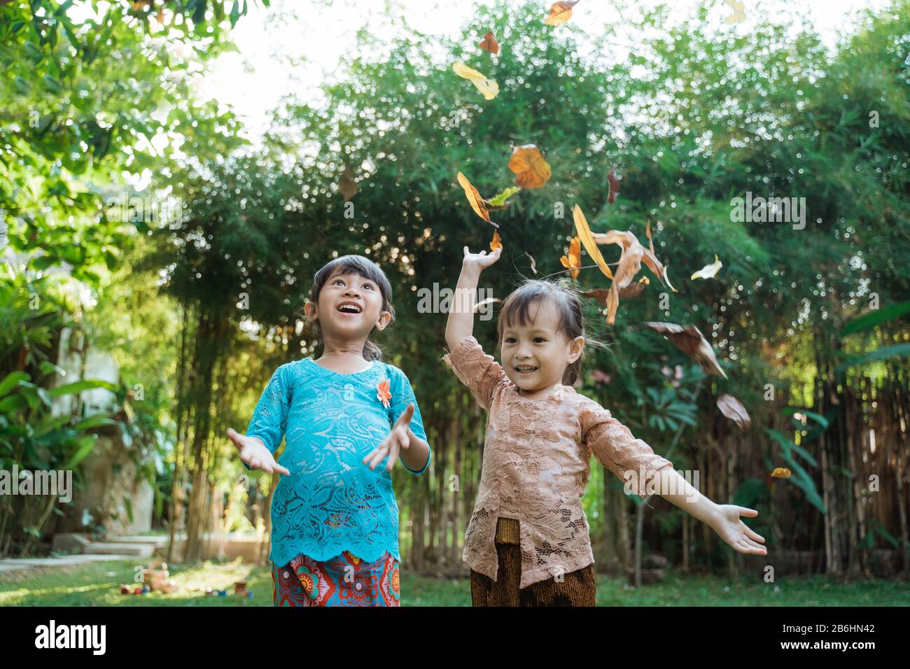 Two pretty girl wearing traditional javanese kebaya playing dried ...