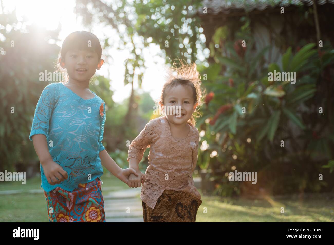 Two pretty girl wearing traditional javanese kebaya with holding hands ...
