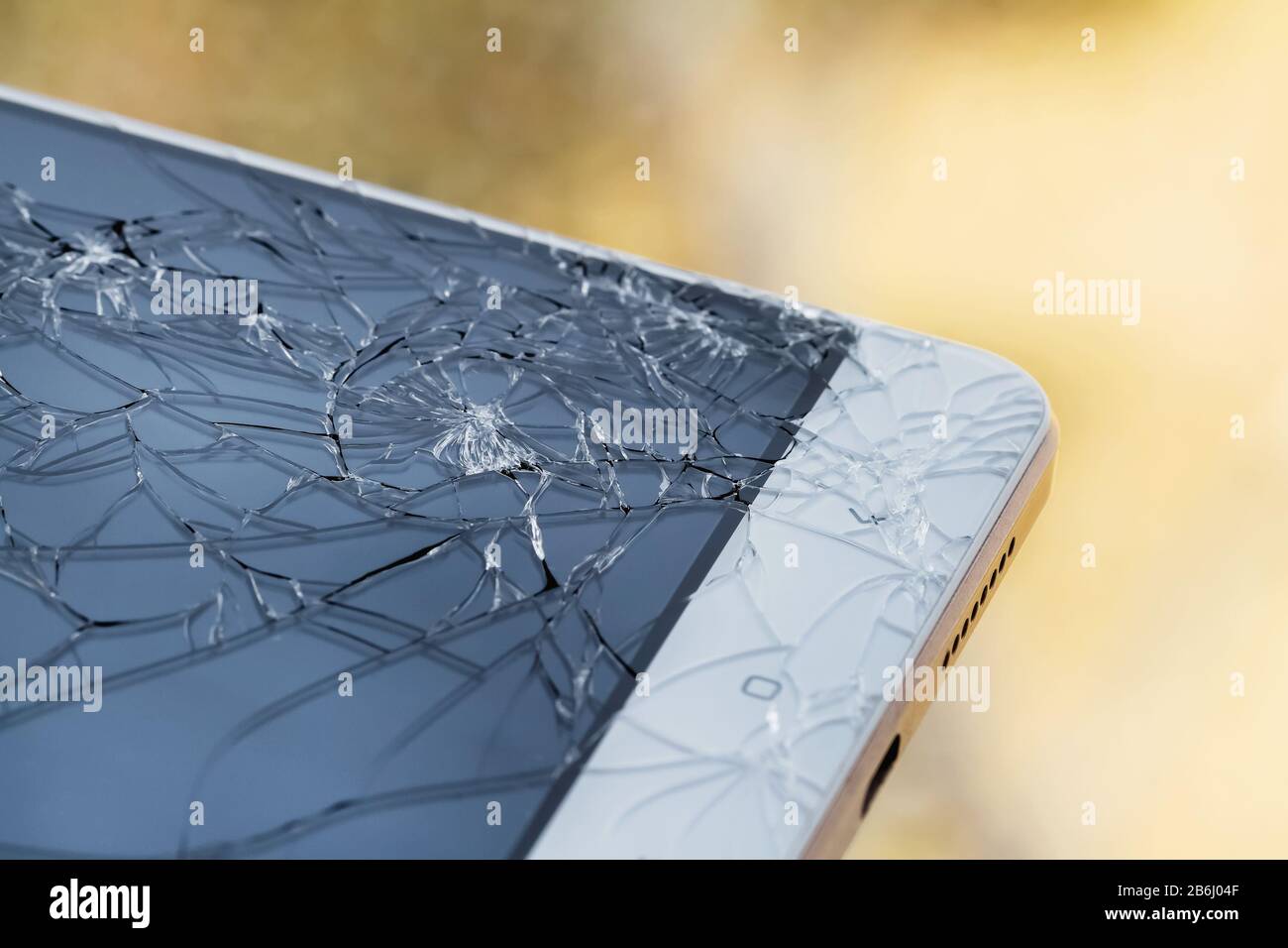 Broken display screen. Damaged smartphone glass. Closeup, yellow ...
