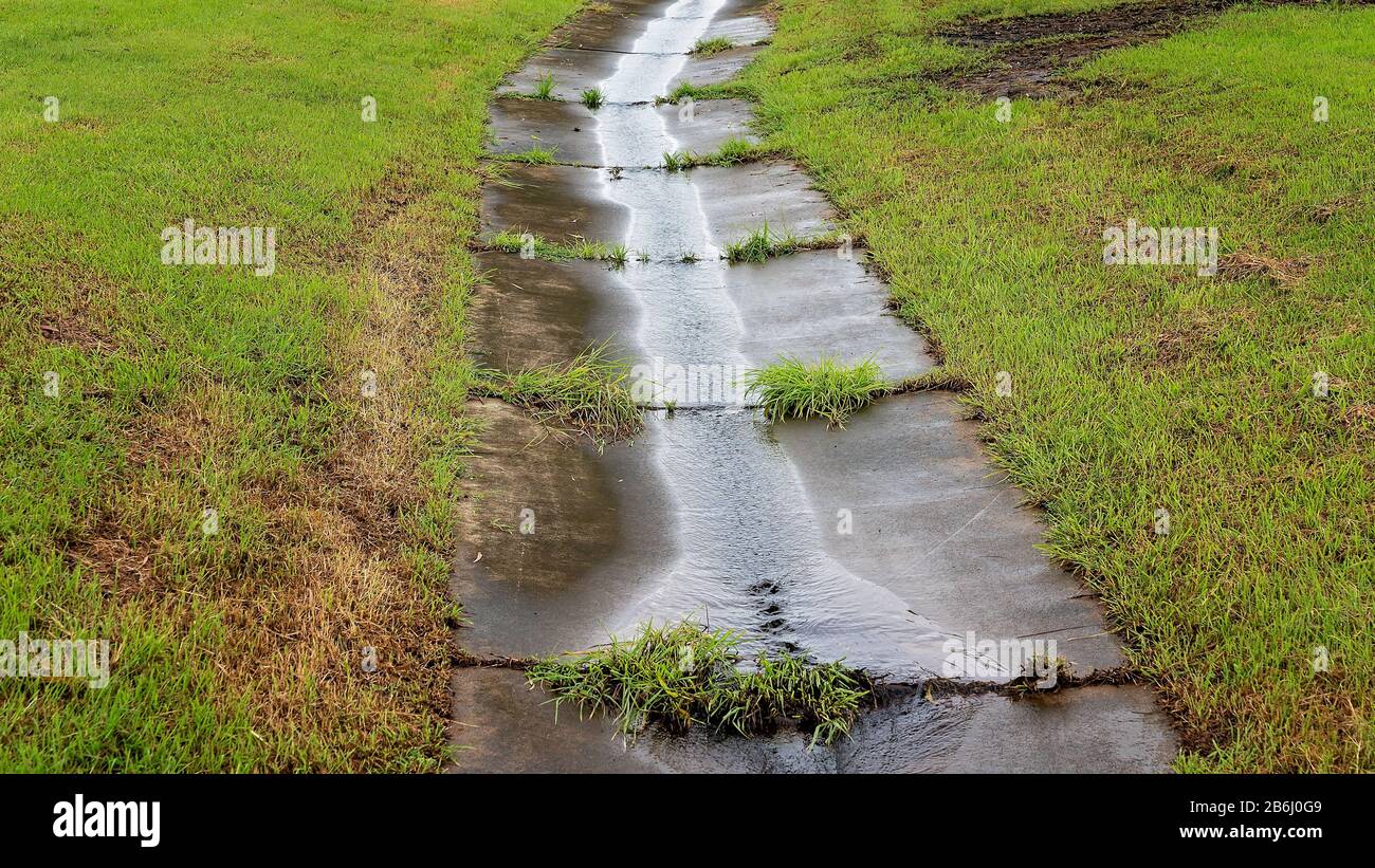 Heavy tropical rainfall causes water to flow in drainage channel Stock ...