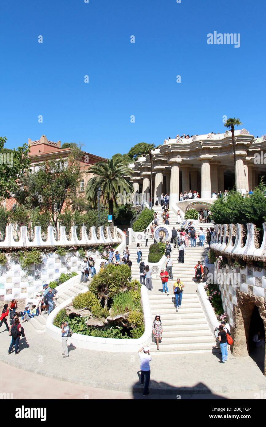 View of the Dragon Stairway and terrace with tourists in Park Guell ...