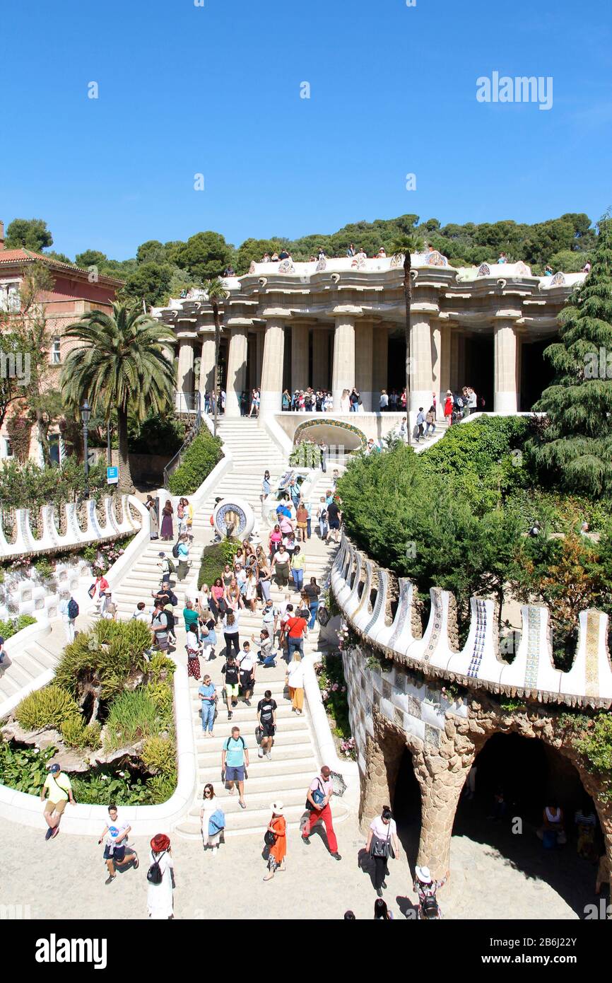 View of the Dragon Stairway and terrace with tourists in Park Guell ...