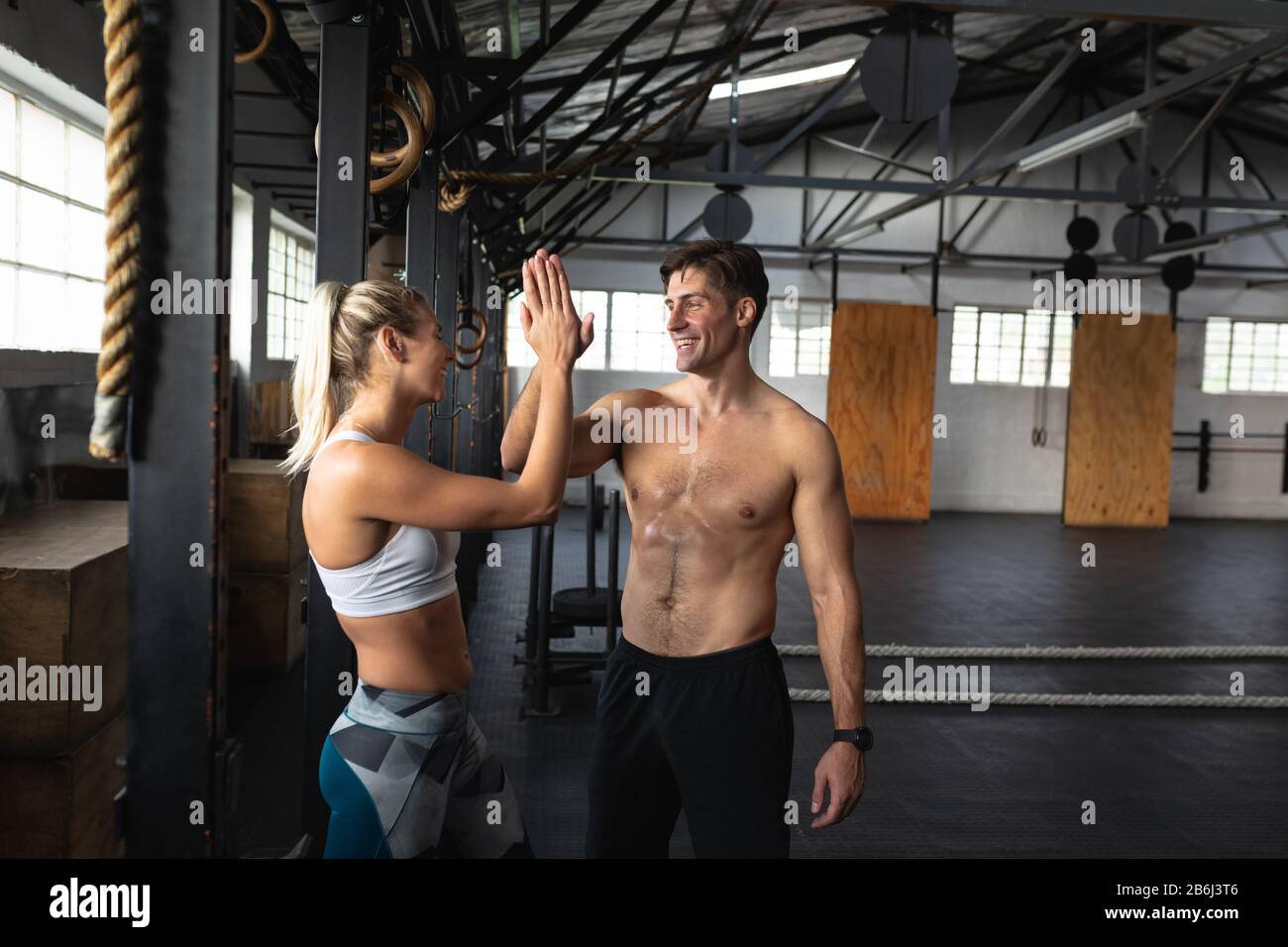 Sporty couple practicing cross training and giving each other a high ...