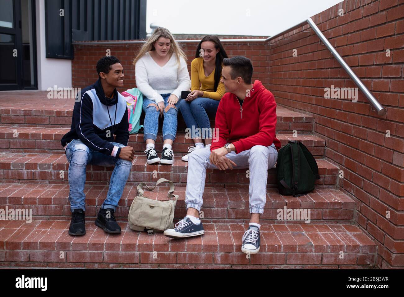 Front view of friends talking together outside Stock Photo - Alamy