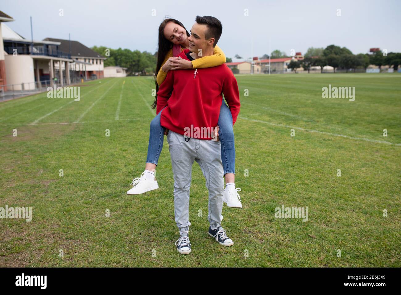 Front view of boyfriend carrying girlfriend outside Stock Photo - Alamy