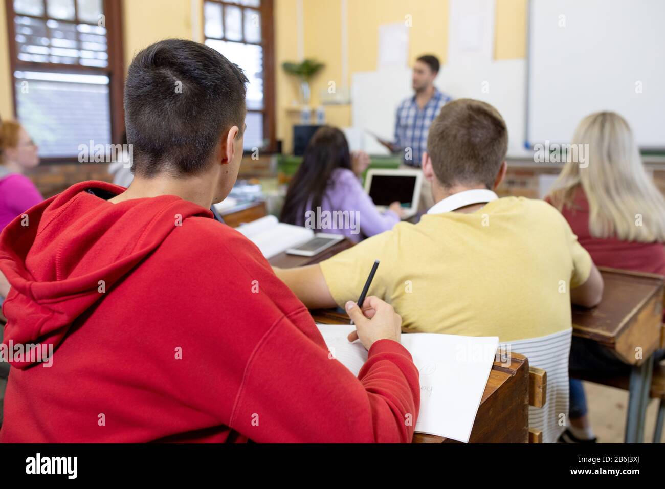 Rear view of students listening to the teacher Stock Photo - Alamy