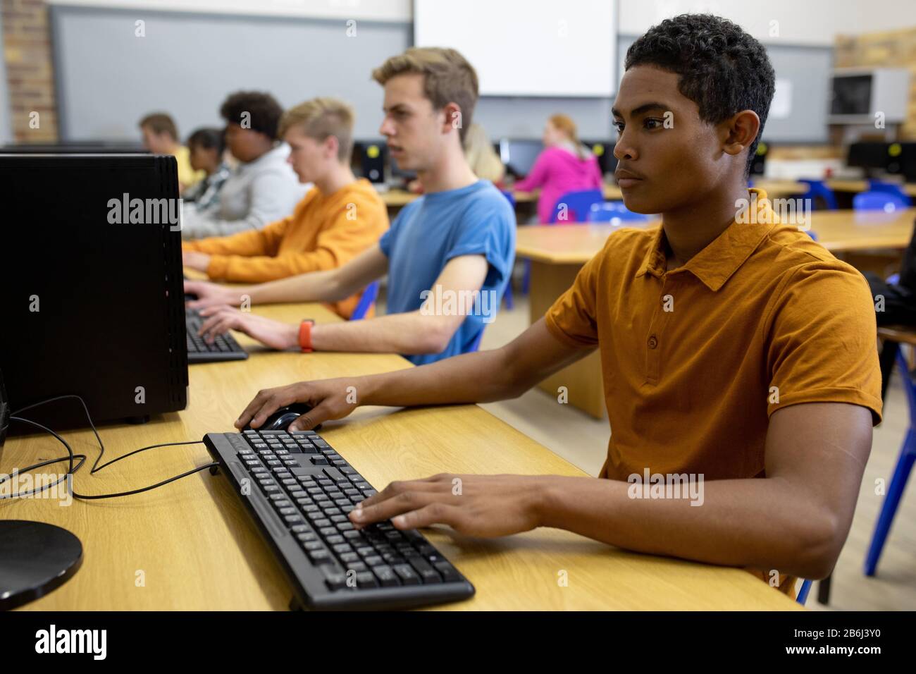 Side view of students working on computers Stock Photo - Alamy